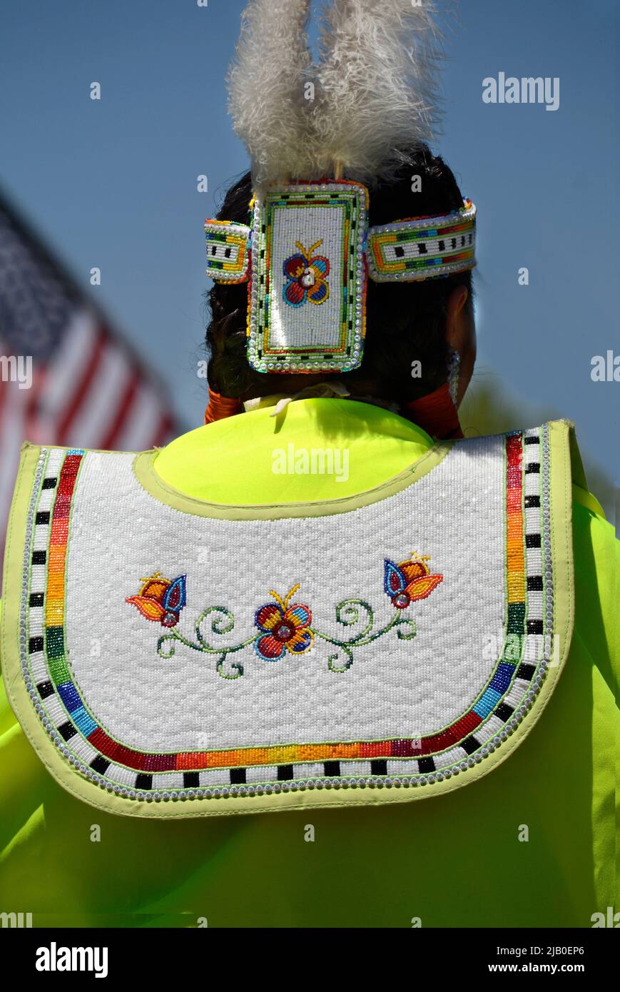 A Native American woman in Native regalia attends a graduation pow wow ...