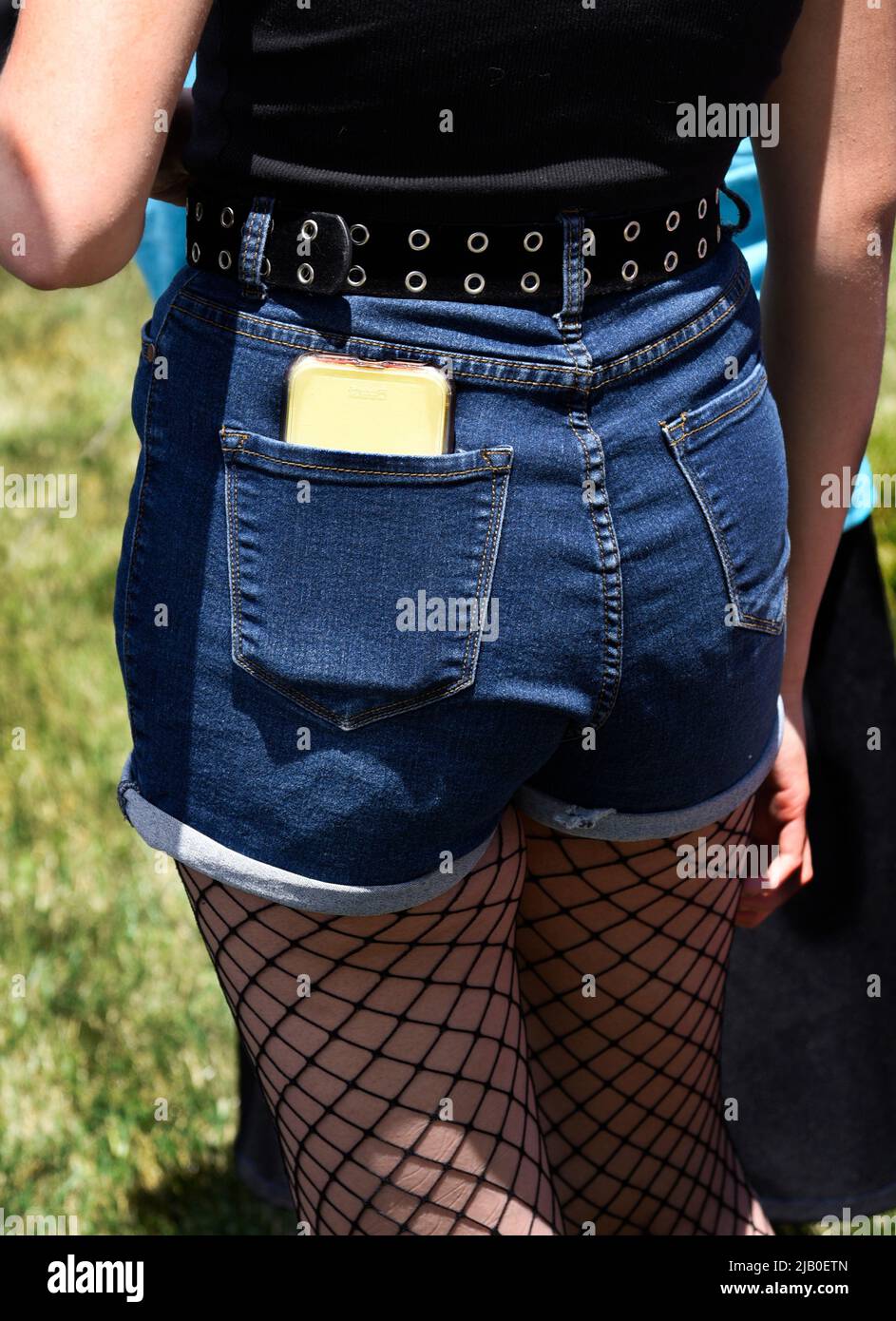 A young Native American woman with a smartphone in her back pocket ...