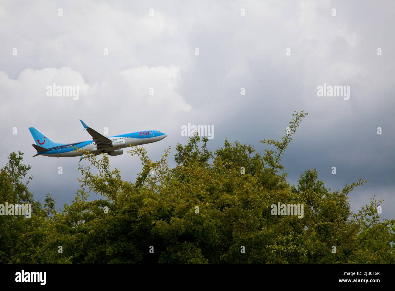 Tui flight leaving Manchester Airport flying over a hedge, Manchester ...