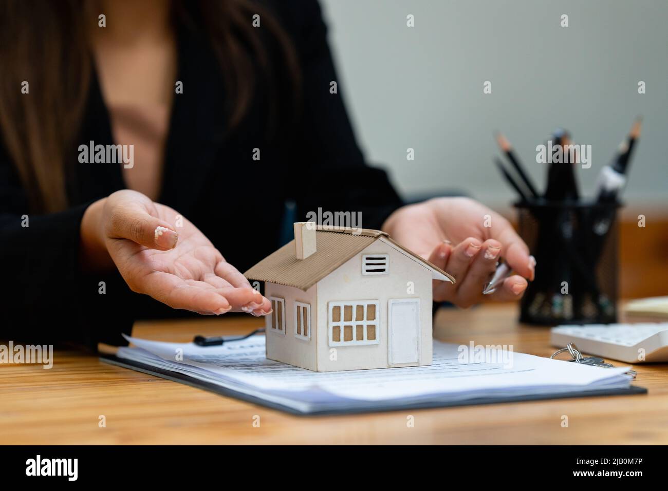 A woman holding and checking house model .Real Estate House Appraisal ...