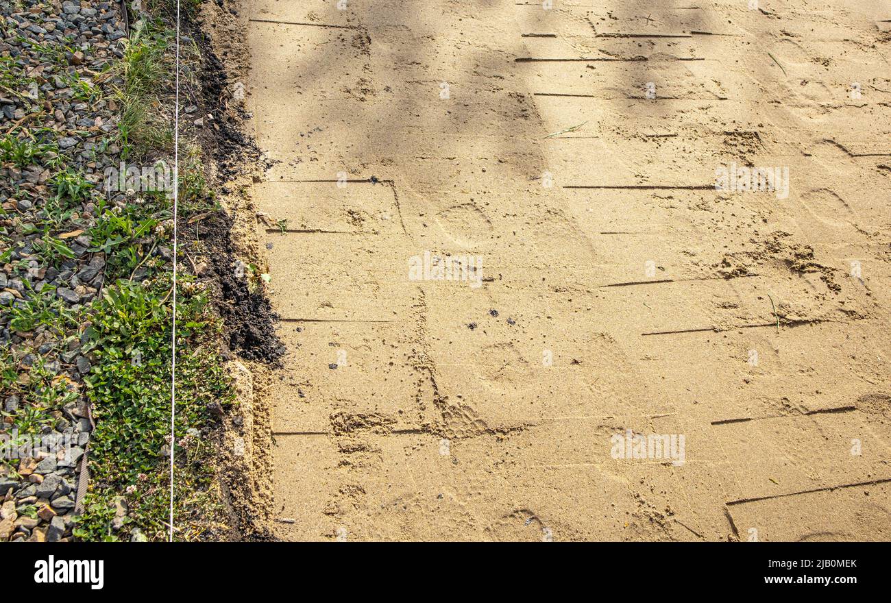 The boundary between wet sand and crushed stone with pebbles on the ...
