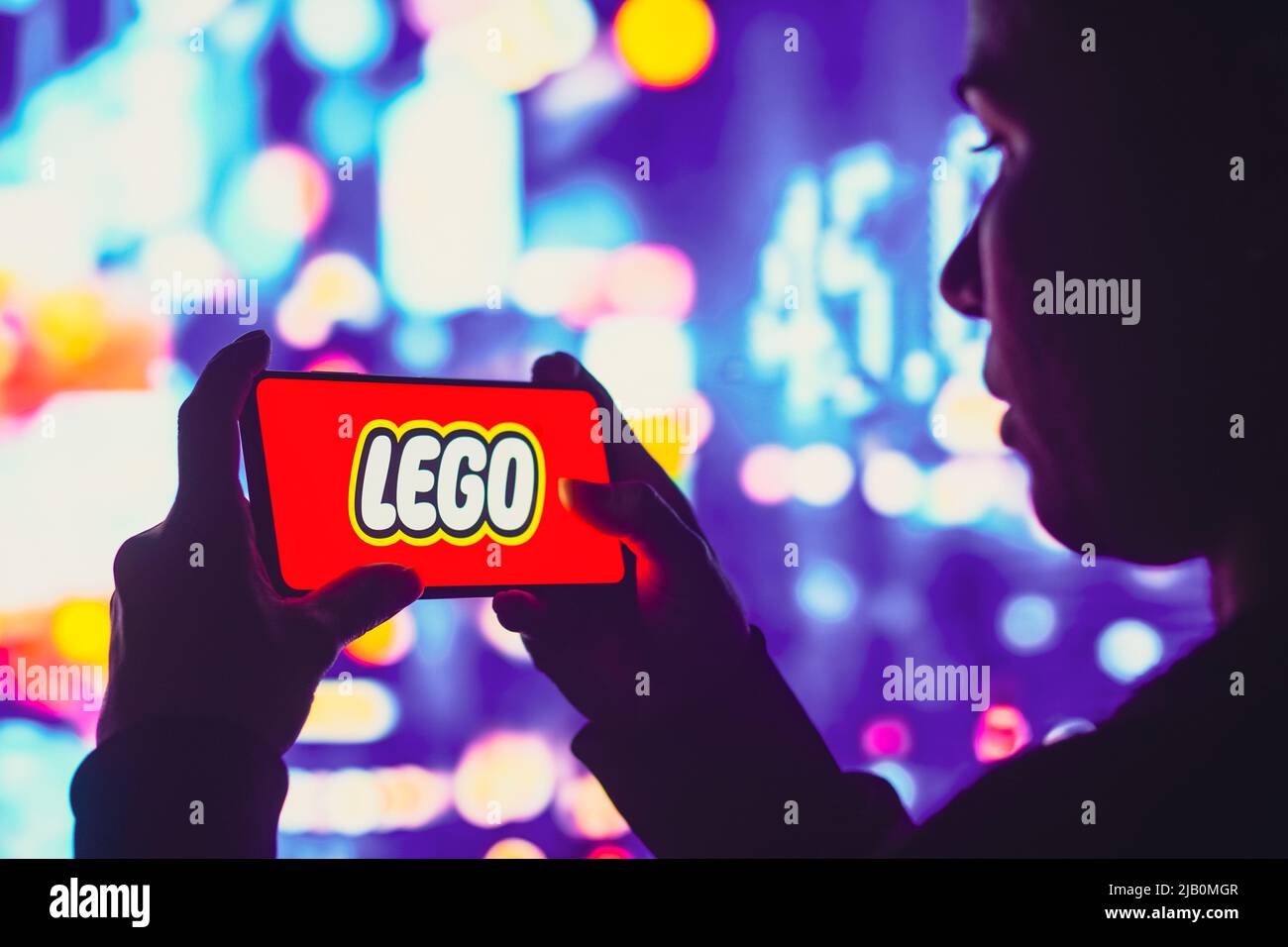 In this photo illustration, a silhouetted woman holds a smartphone with ...