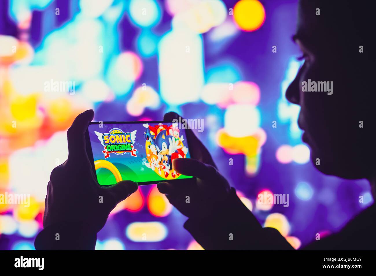 In this photo illustration, a silhouetted woman holds a smartphone with ...