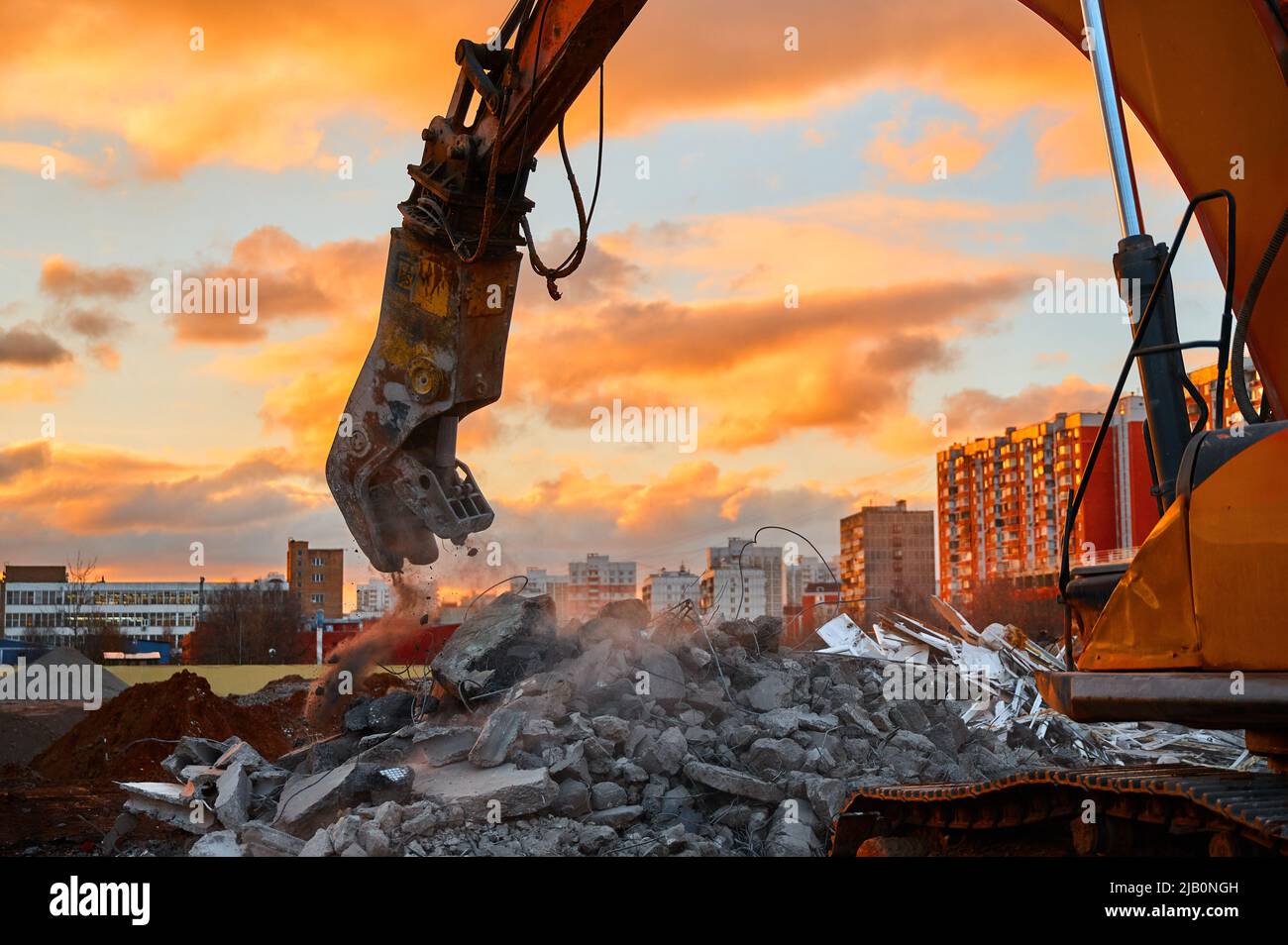 Crusher destroys reinforced concrete at demolition site Stock Photo - Alamy