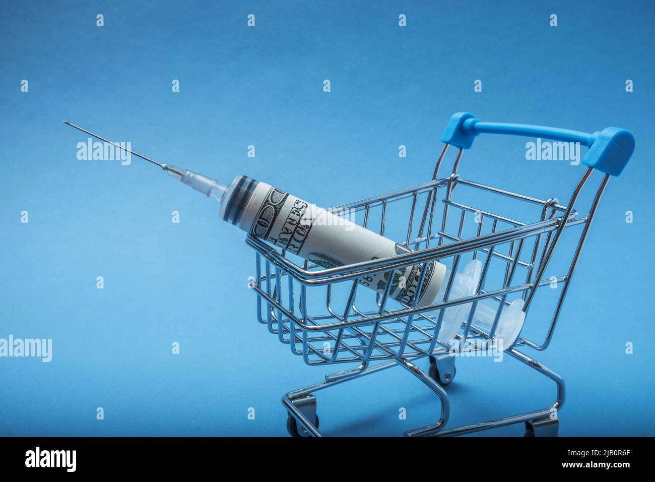 The syringe wrapped in a dollar is in the basket. Offering a financial ...