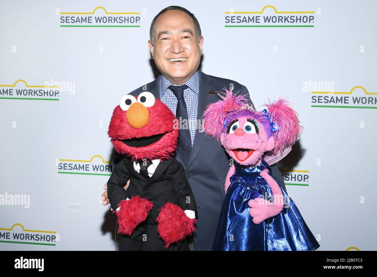 Actor Alan Muraoka poses with Sesame Street characters Elmo and Abby ...