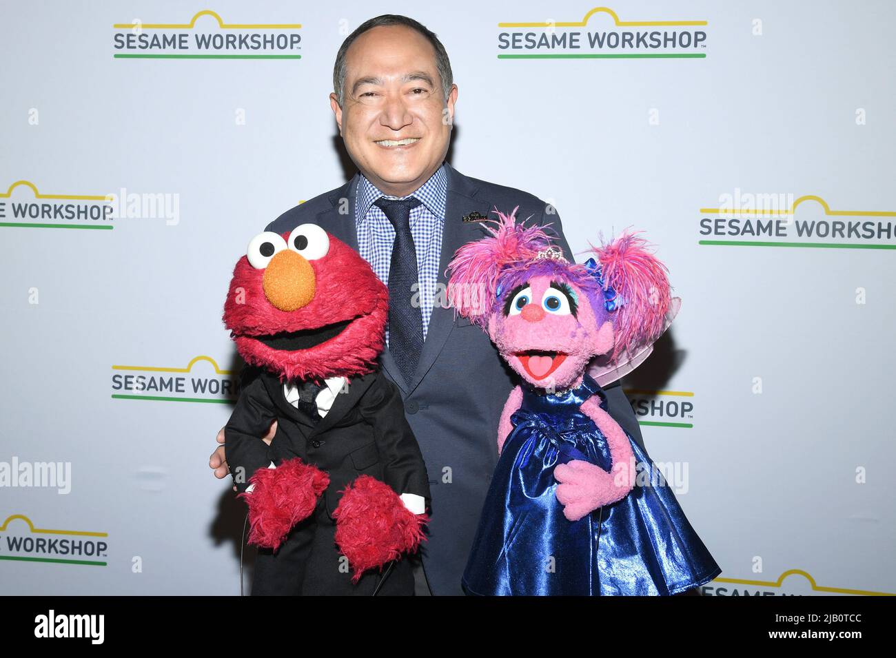 Actor Alan Muraoka poses with Sesame Street characters Elmo and Abby ...