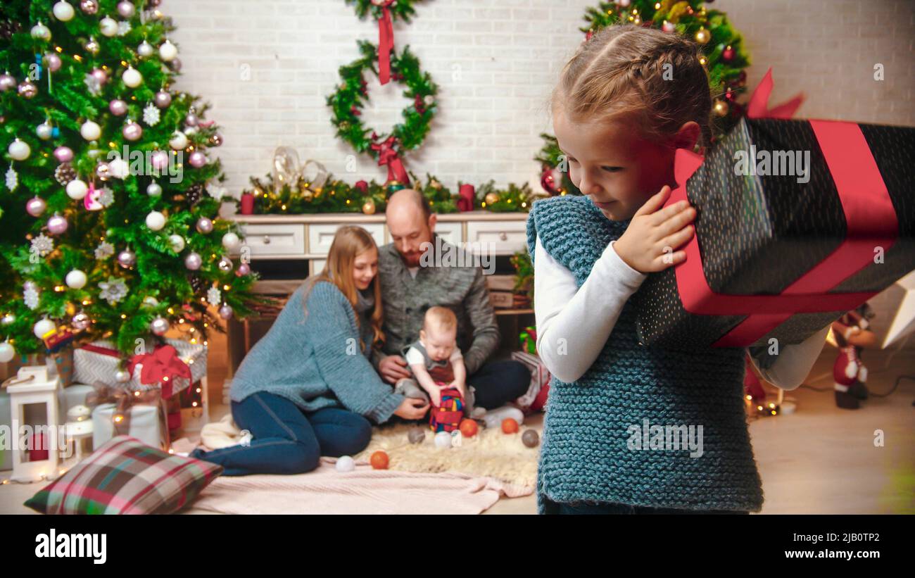 NEW YEAR CONCEPT - daughter shaking a gift Stock Photo - Alamy