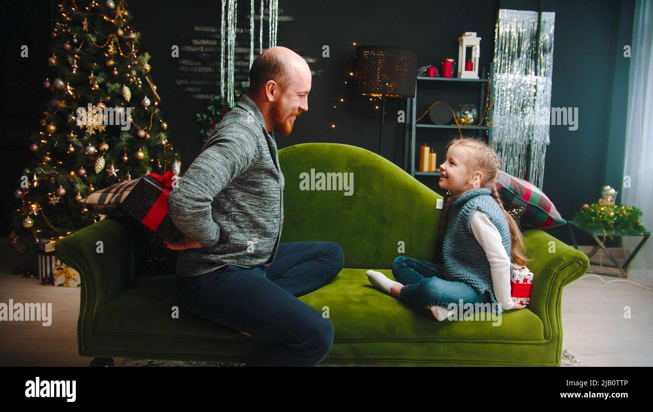 Christmas concept - a dad with daughter exchanging gifts on christmas ...