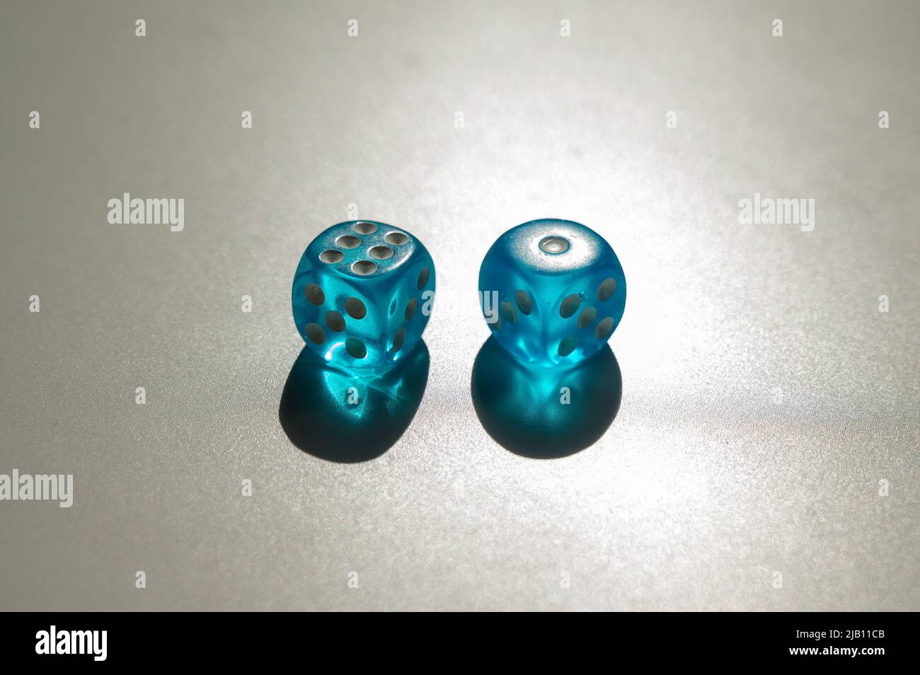 Two transparent blue dice on a white table Stock Photo - Alamy