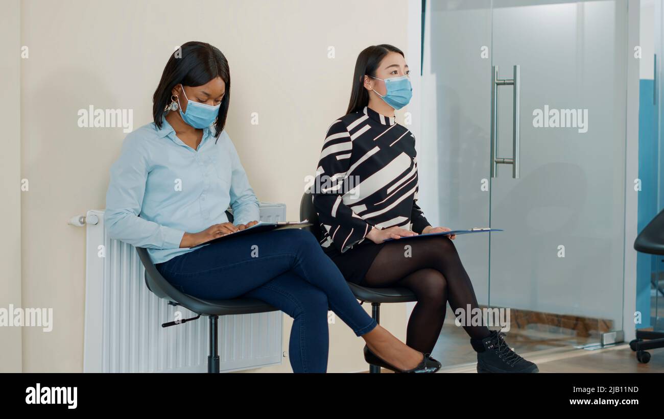 Nervous women waiting in queue to join job interview, preparing with cv ...