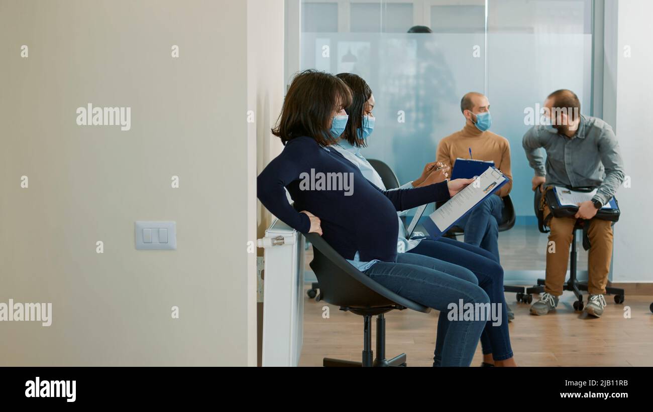 Woman with pregnancy belly dropping cv files on floor while she waits ...