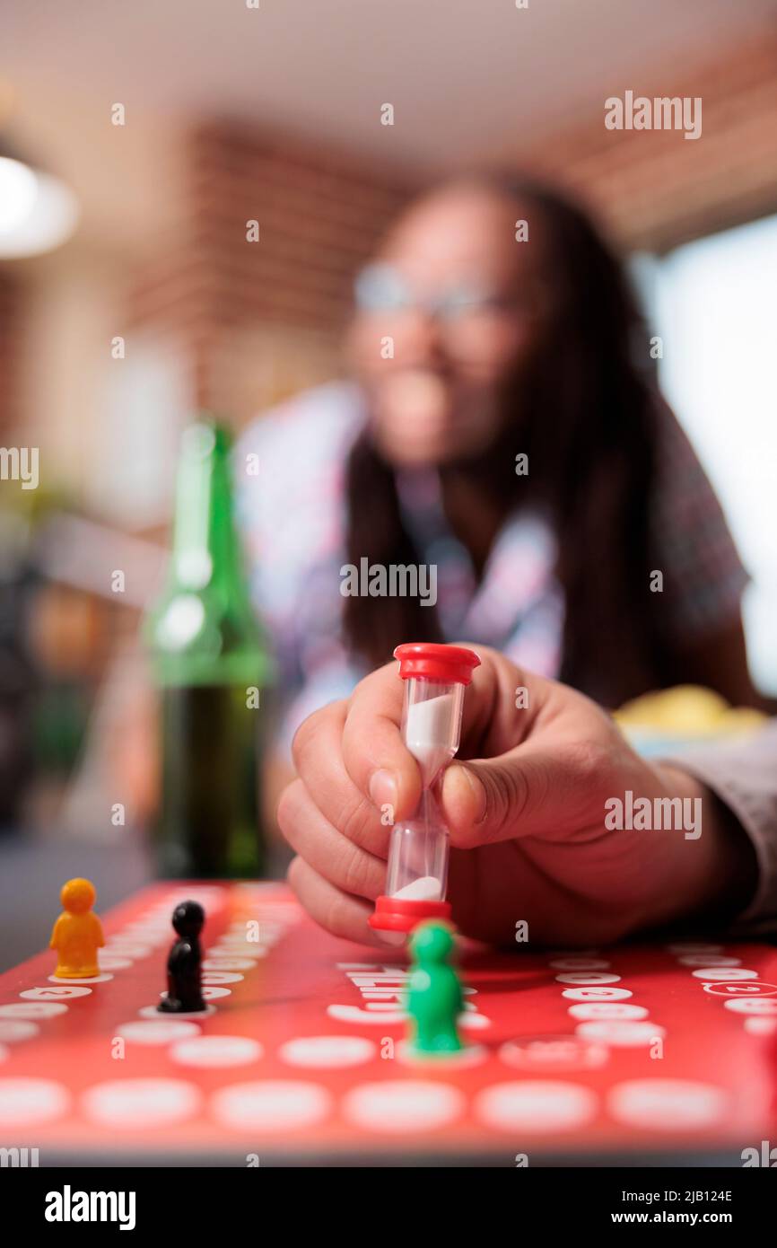 Close up shot of caucasian man hand holding boardgame hourglass while ...