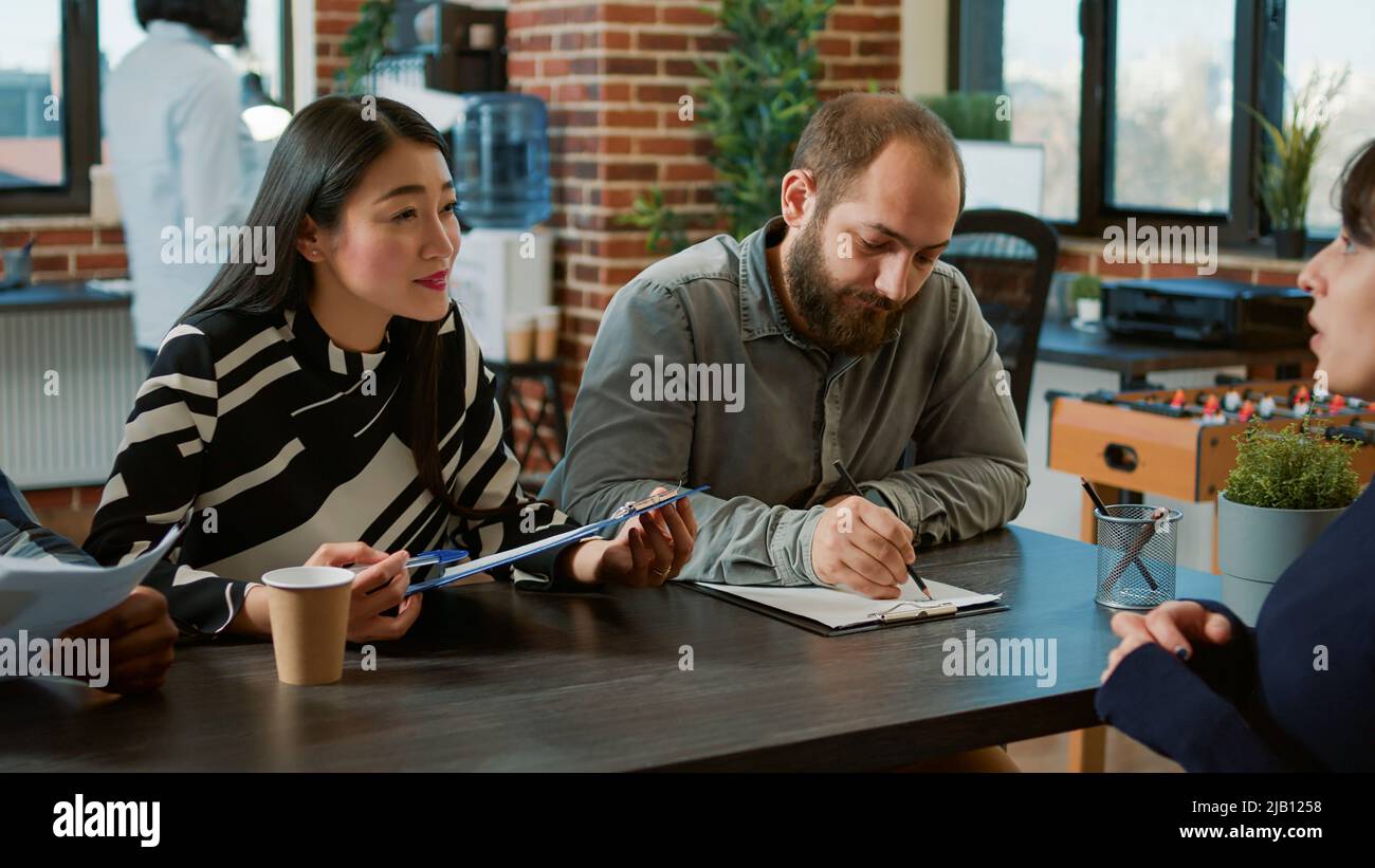 Multiethnic group of workers talking to candidate at recruiting ...