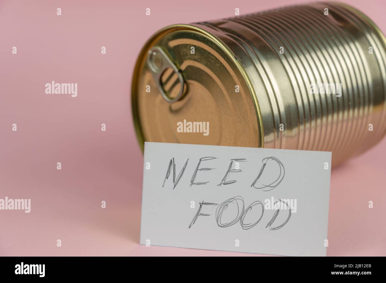 Need food. Business card with handwritten text and canned food against ...