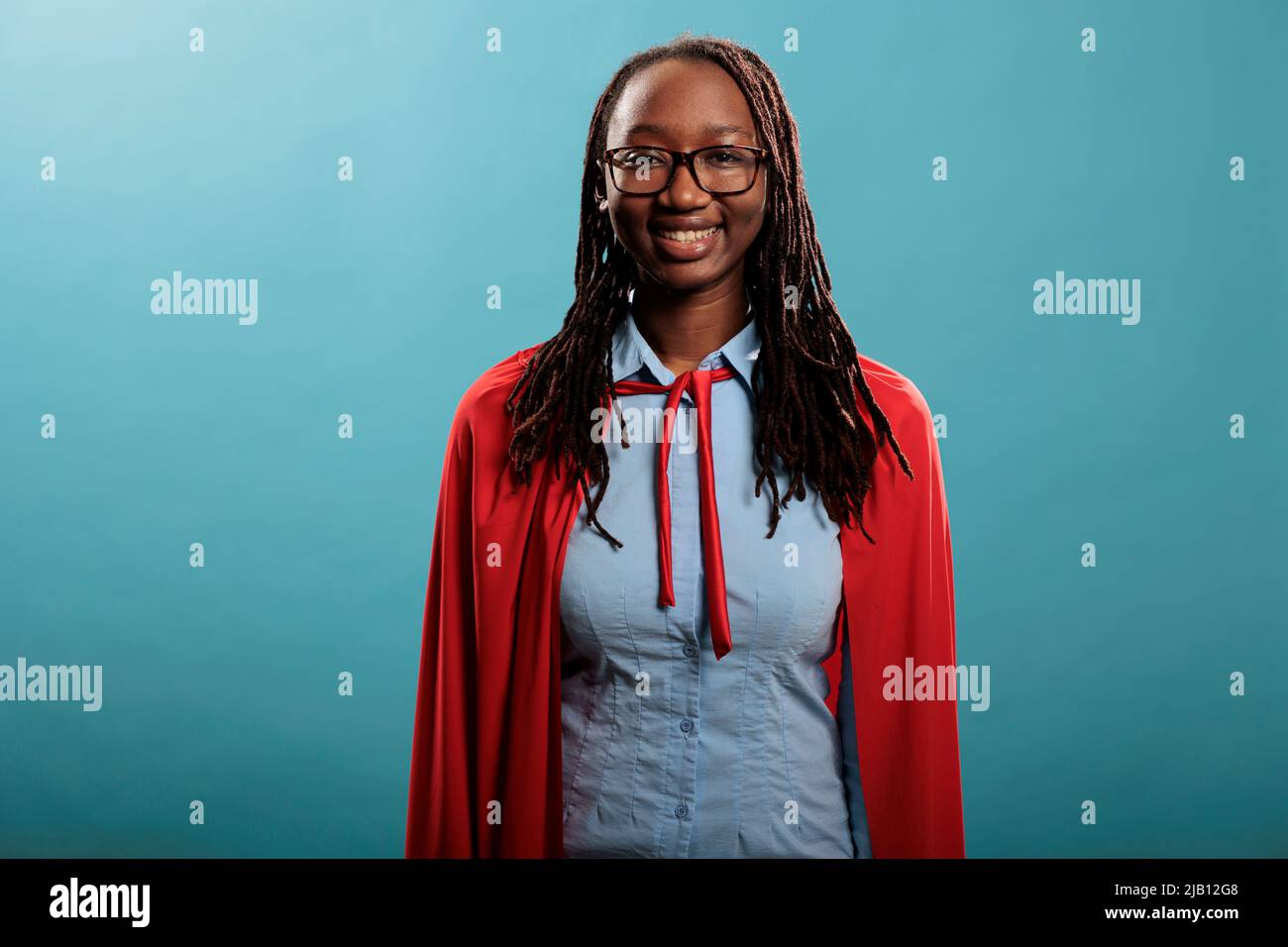 Optimistic looking superhero woman wearing hero costume while smiling ...