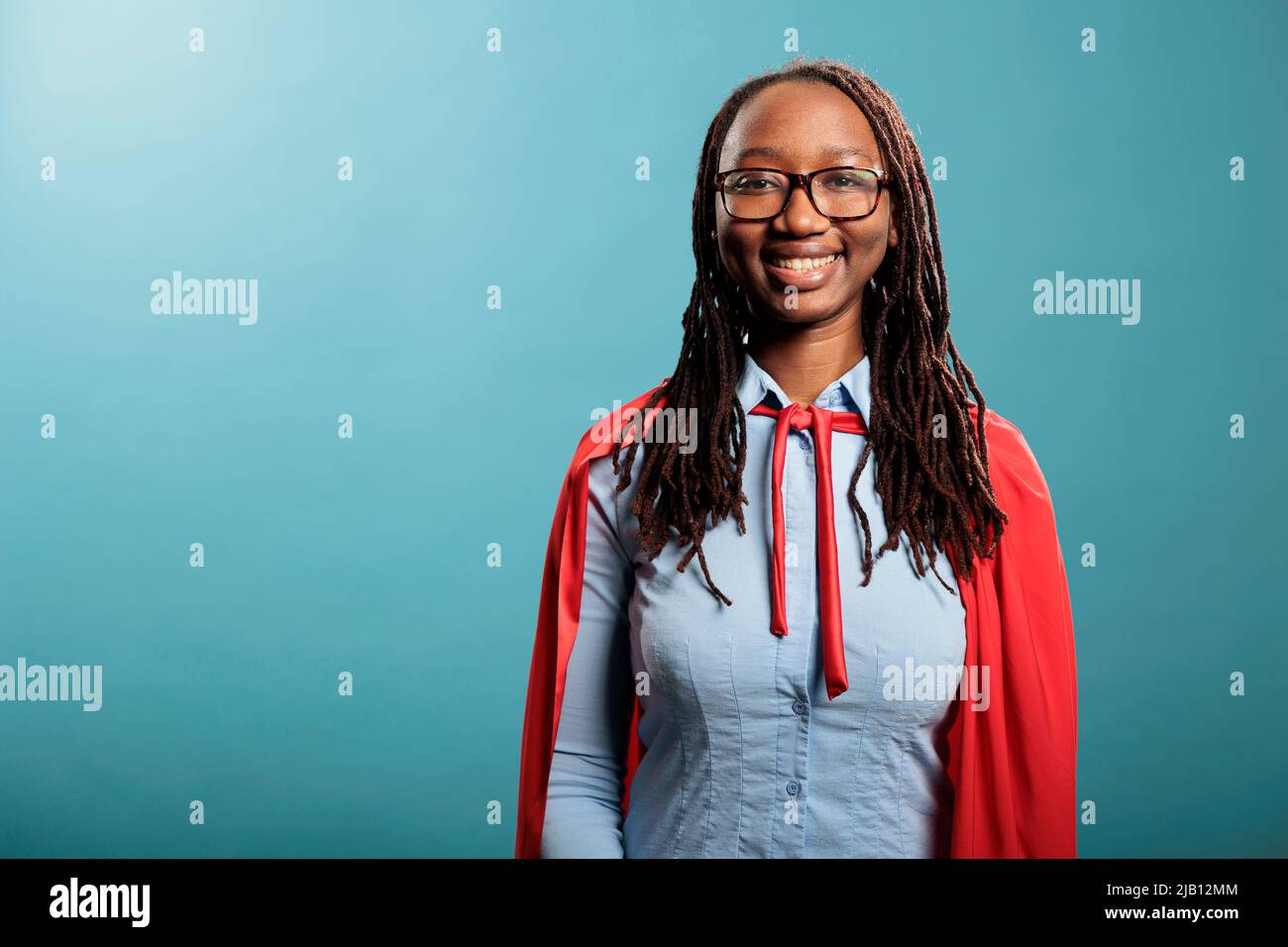 Young adult optimistic and strong superhero woman wearing hero cloak ...