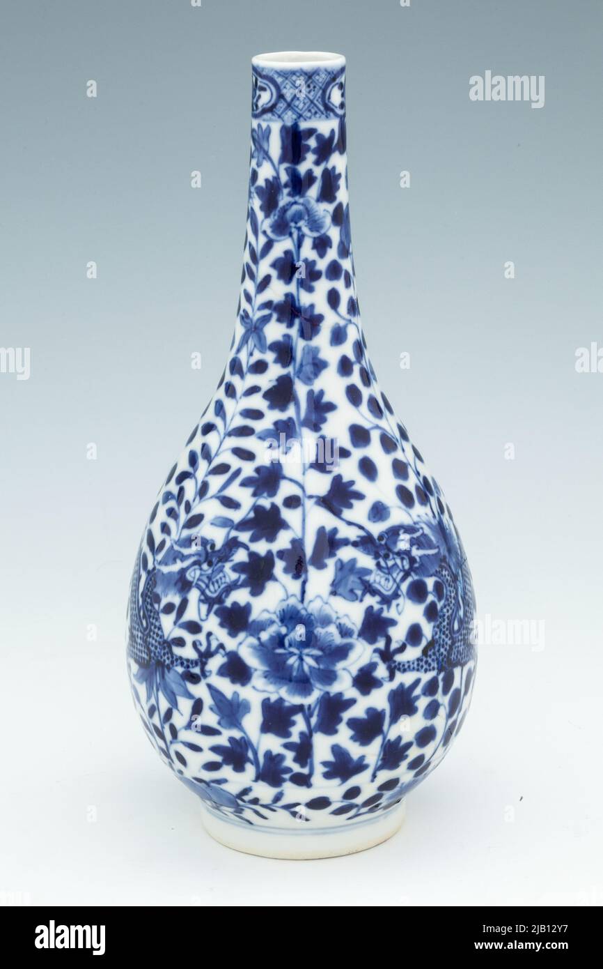 A vase in the shape of a cylinder with a dragon motif among plant ...