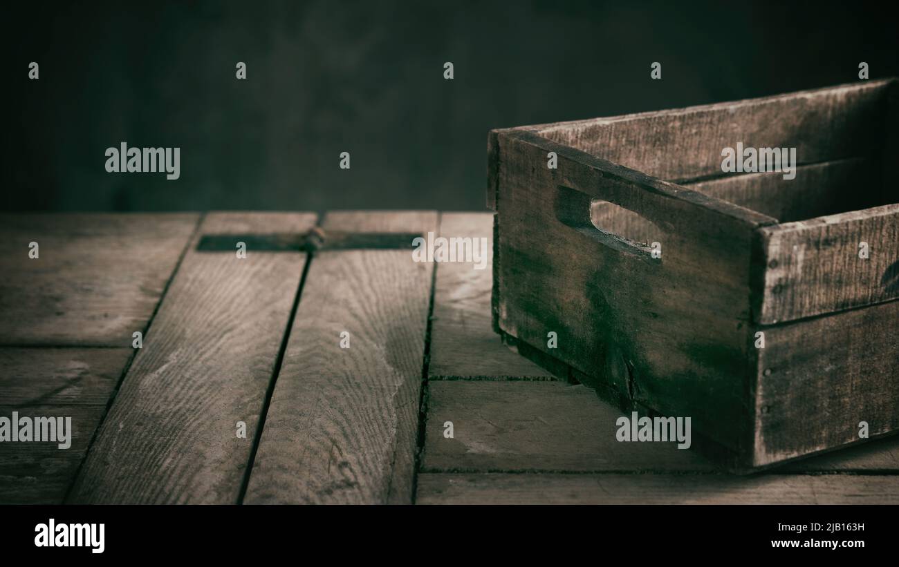 High angle of empty aged wooden vegetable box placed on timber table in ...
