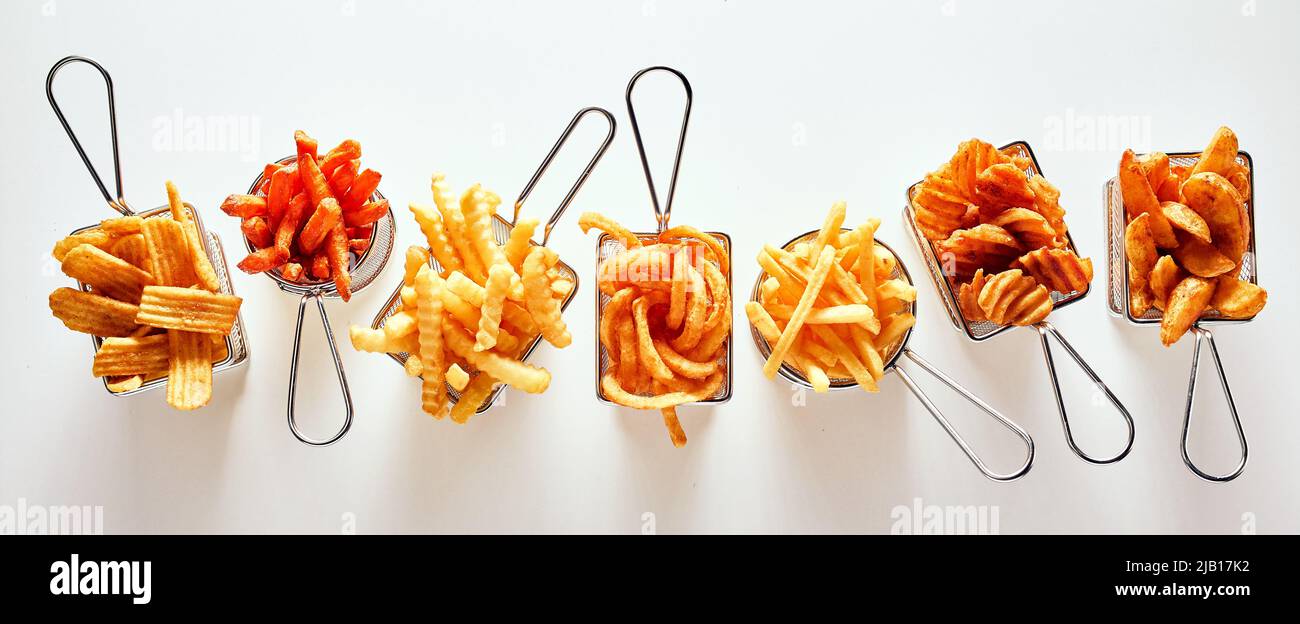 From above of assorted tasty French fries and potato chips in metal ...