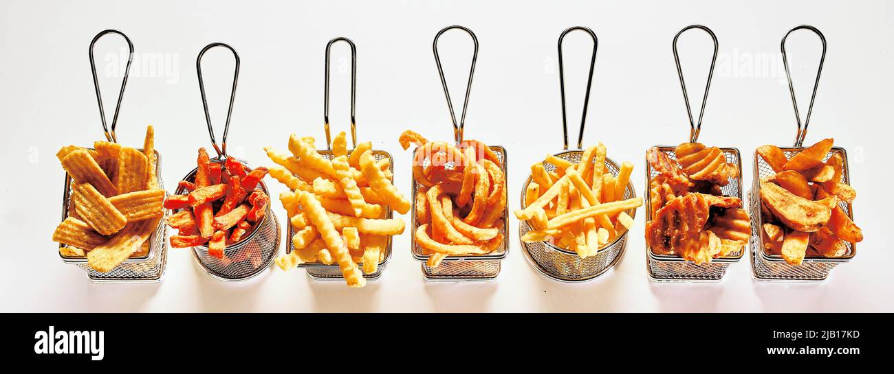 Top view of assorted French fries and crunchy potato chips in metal ...