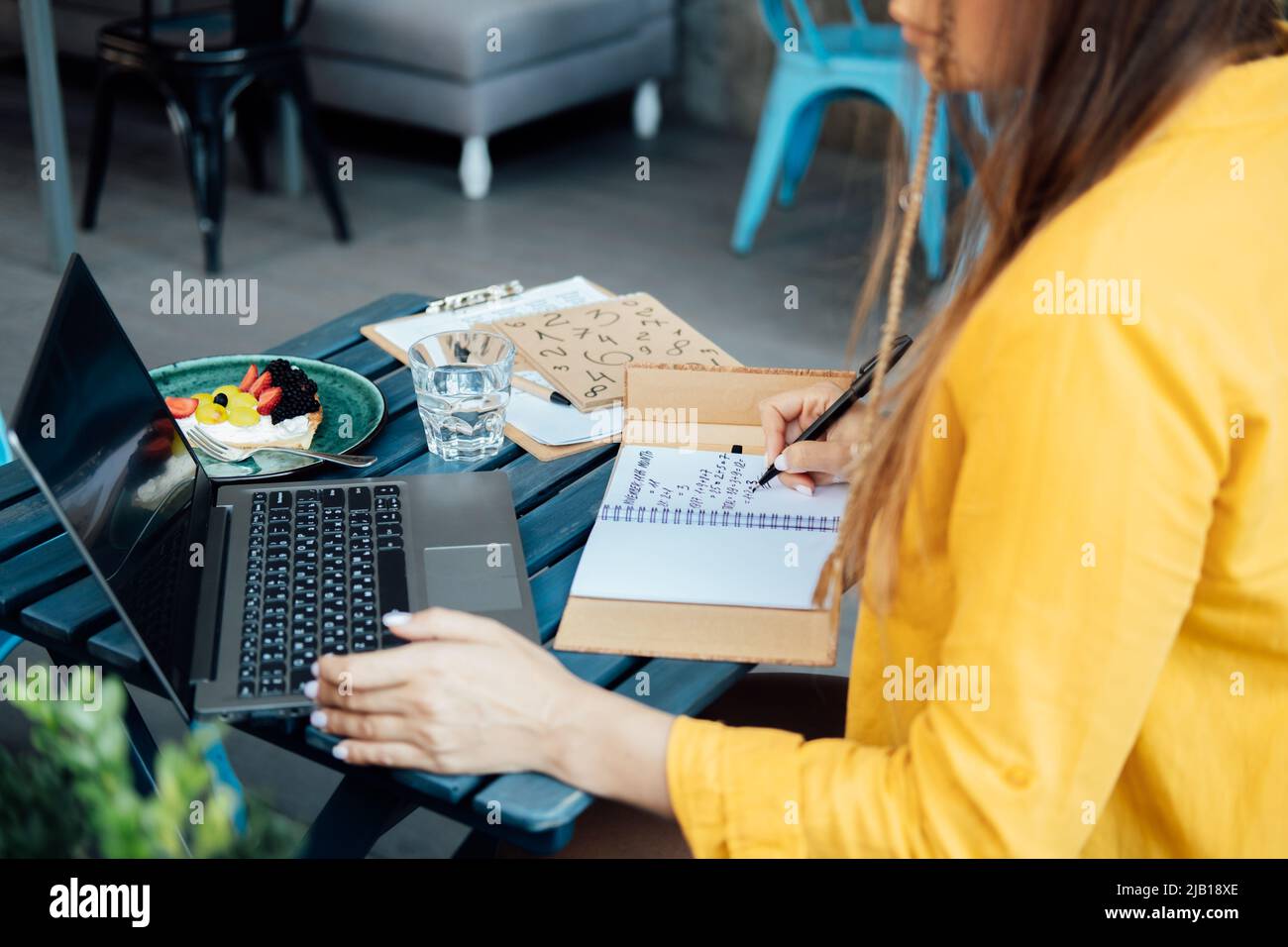 Woman numerologist working with numbers in notepad and laptop ...