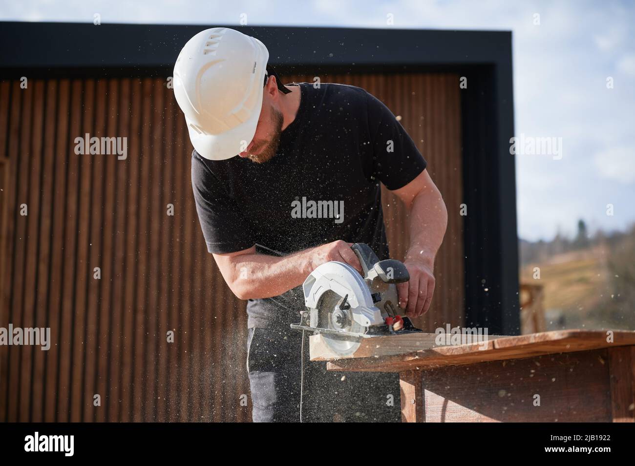 Carpenter using circular saw for cutting wooden plank. Man worker ...