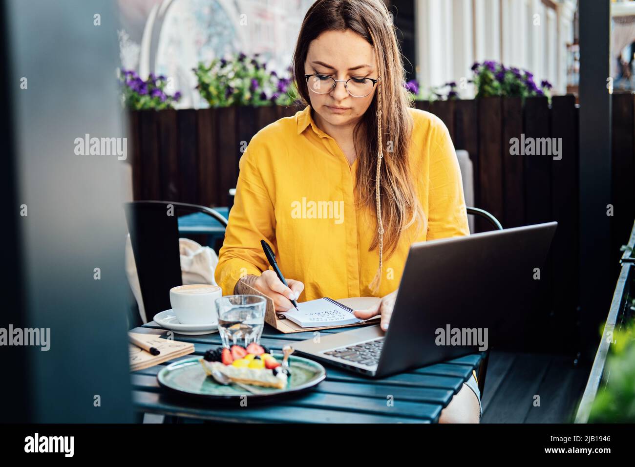 Woman numerologist working with numbers in notepad and laptop ...