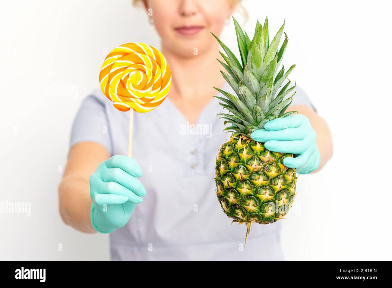 Young caucasian female doctor nutritionist holding fresh pineapple with ...