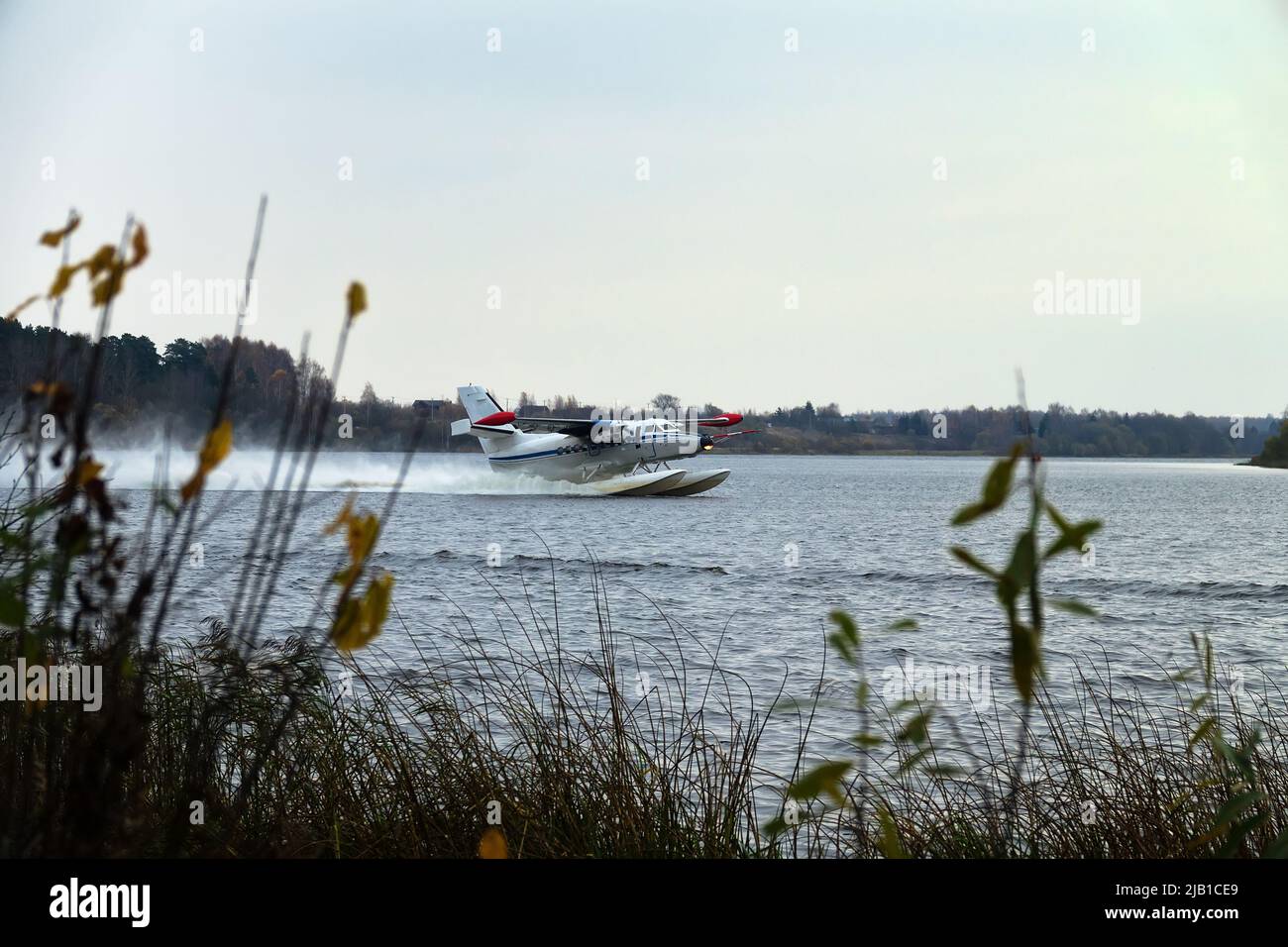 The Twin-engine seaplane a seaplane rises from water, from the forest ...