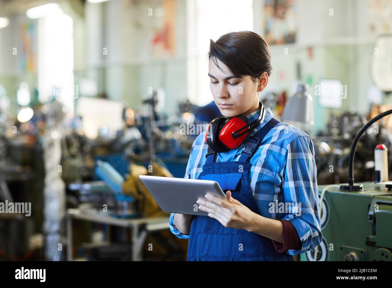 Serious thoughtful lady worker with short black hair standing in ...