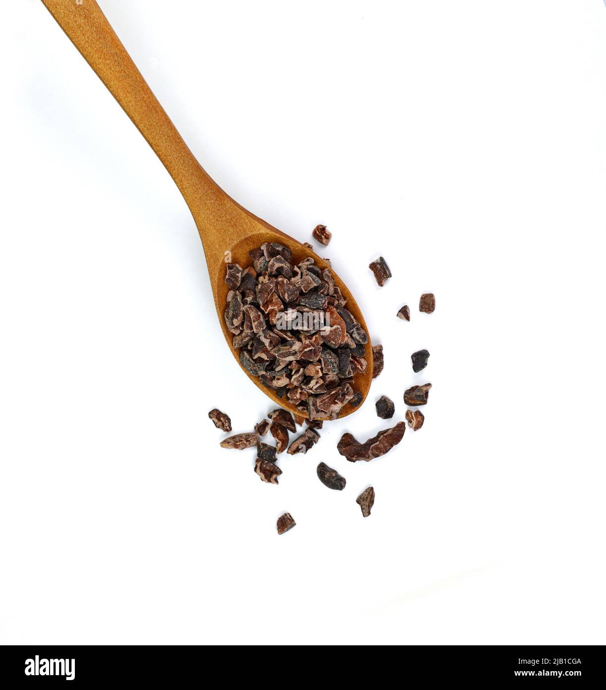 Cocoa nibs, a pieces of broken cocoa beans in a wooden spoon isolated ...