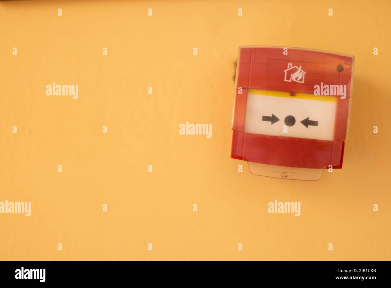 Fire alarm system button on a yellow wall. Copy space Stock Photo - Alamy