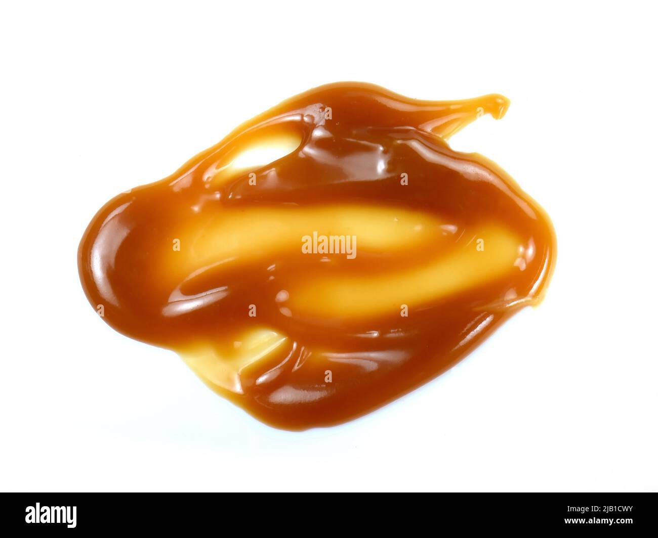Sweet caramel sauce isolated on white background close up. Golden ...