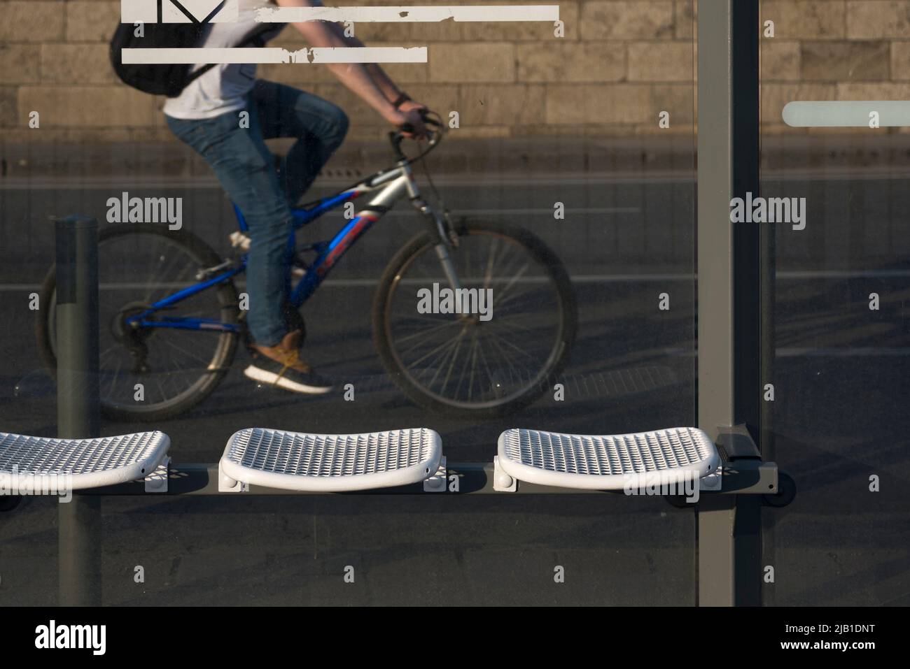 Person riding a bicycle passes public transport stop Stock Photo - Alamy