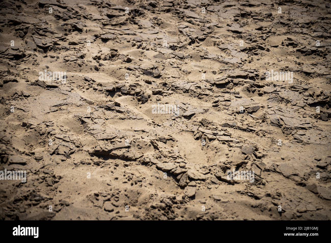 Closeup surface of sand dune in dark mood. The field is roughly tramped ...