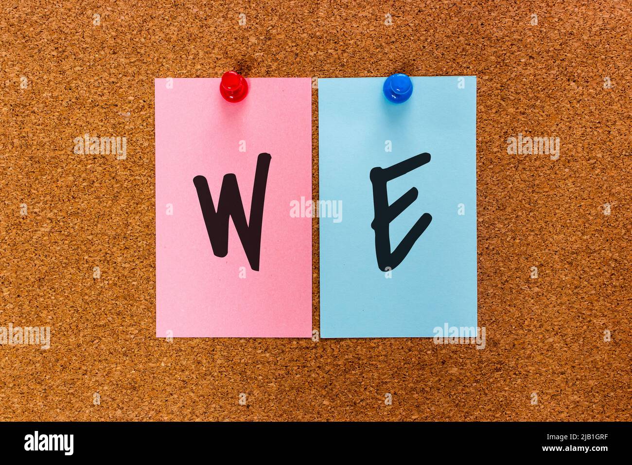 Conceptual 2 letter WE by handwriting on multicolored stickers attached ...