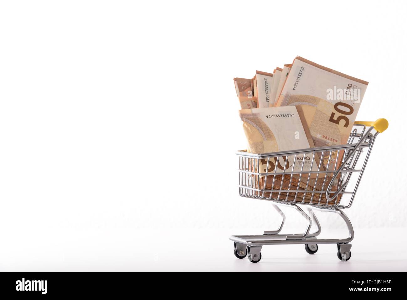 Toy supermarket cart or shopping trolley with money isolated on white ...