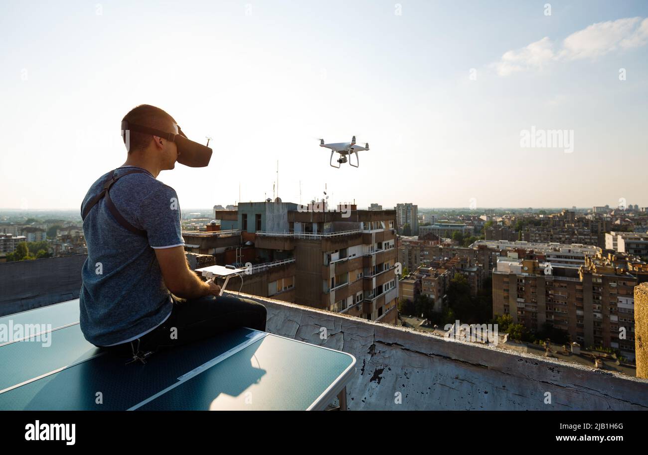 Young technician flying UAV drone with remote control on rooftop Stock ...