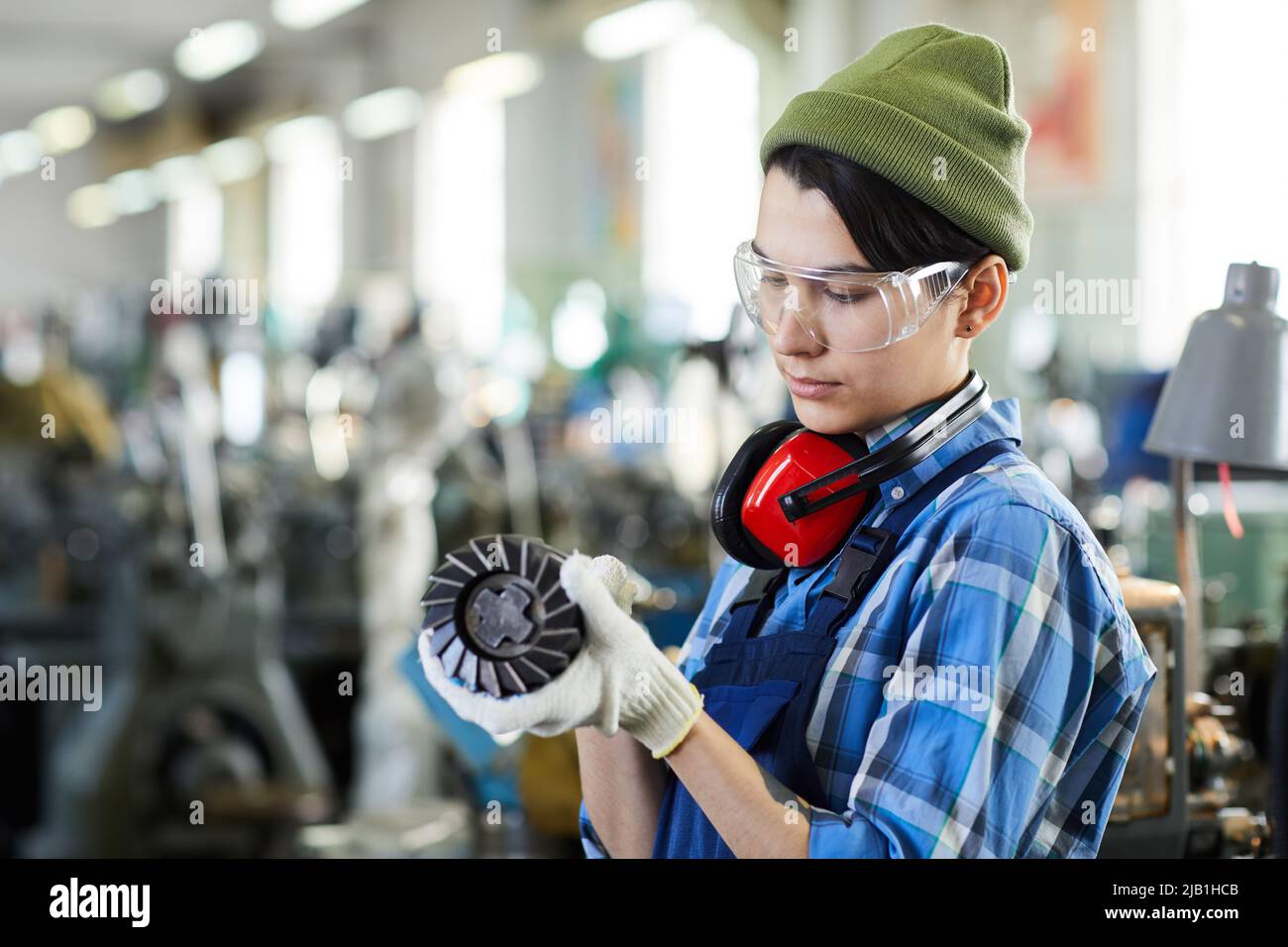 Concentrated tough lady occupied in industrial repair sphere standing ...