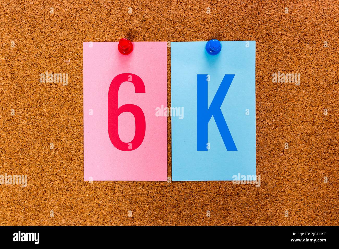 2 letters keyword 6K on multicolored stickers attached to a cork board ...