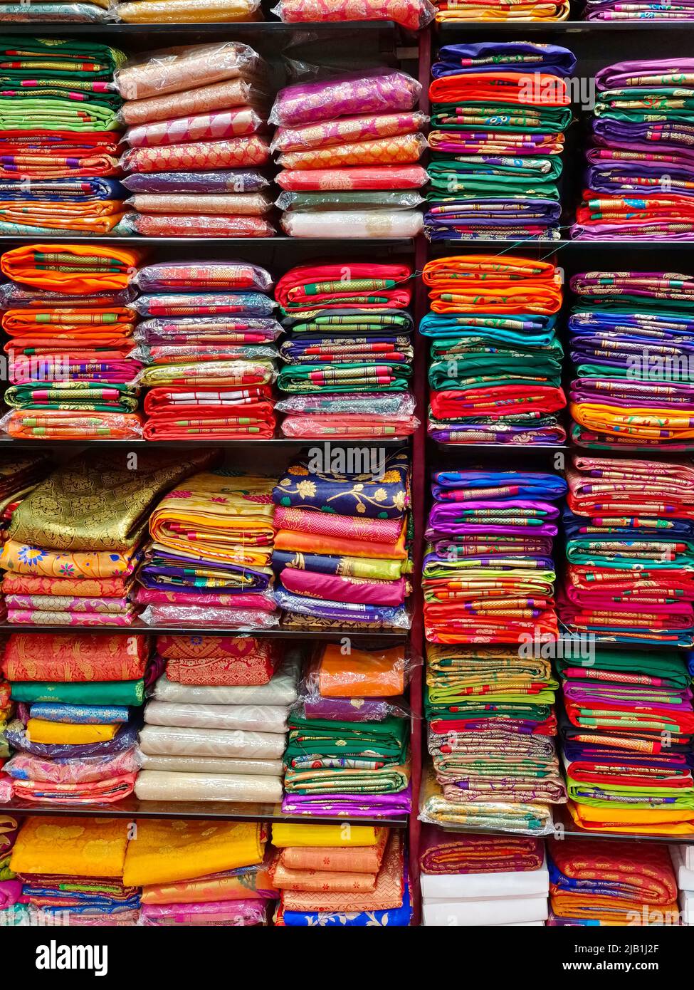 Fancy Indian sarees, Neatly stacked colorful silk saris in racks in a ...