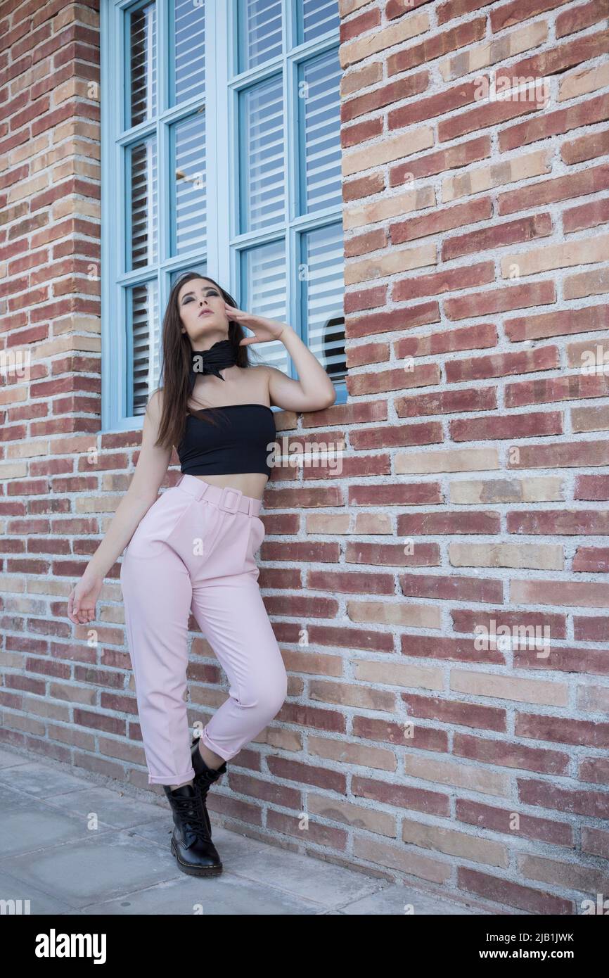 Full body side view of young female in trendy outfit standing near ...