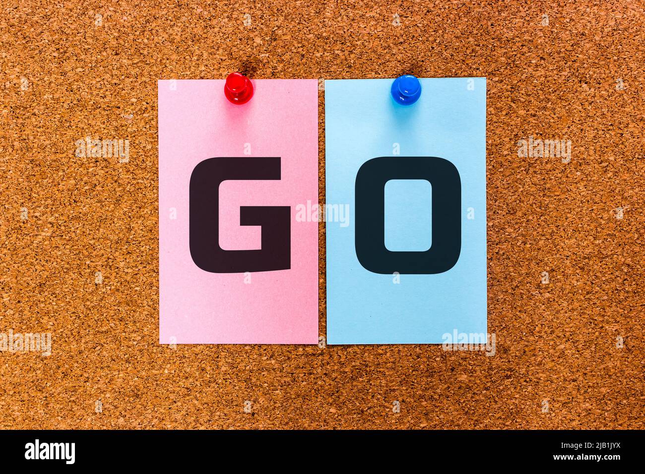 Conceptual 2 letters keyword GO on multicolored stickers attached to a ...