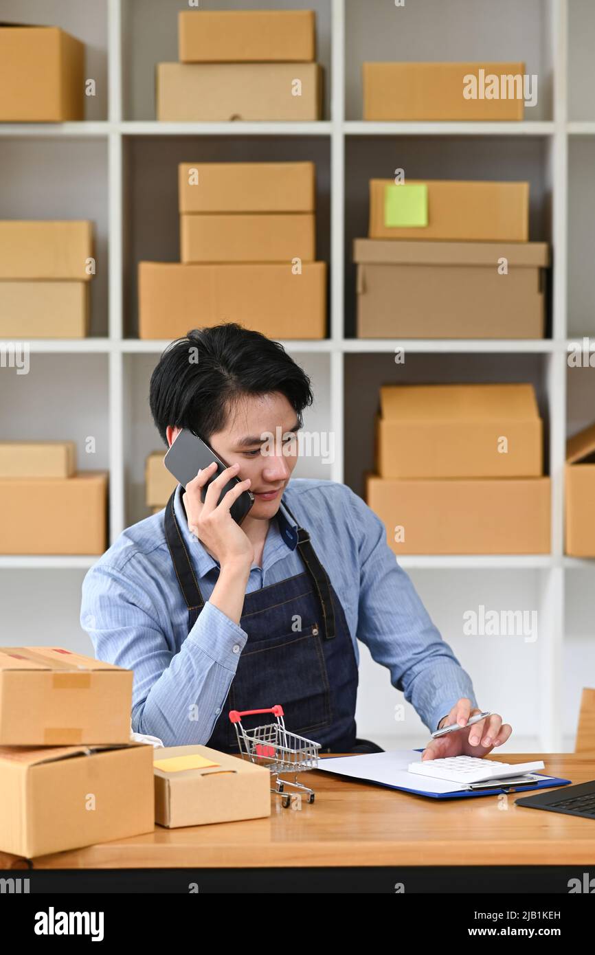 Young male small business owner having cell phone conversation for ...