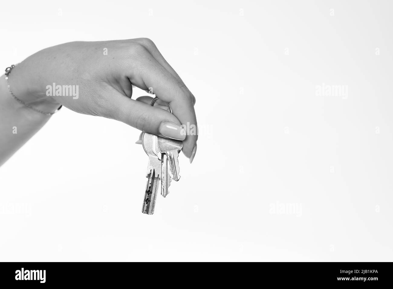 A hand holding keys on a white background in black and white Stock ...