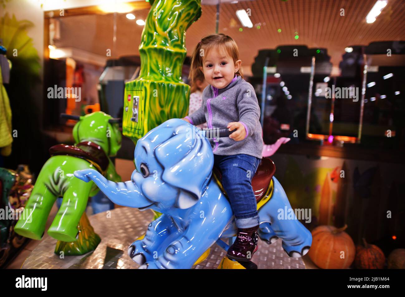 Two sisters rides an elephant carousel in fun children center Stock ...