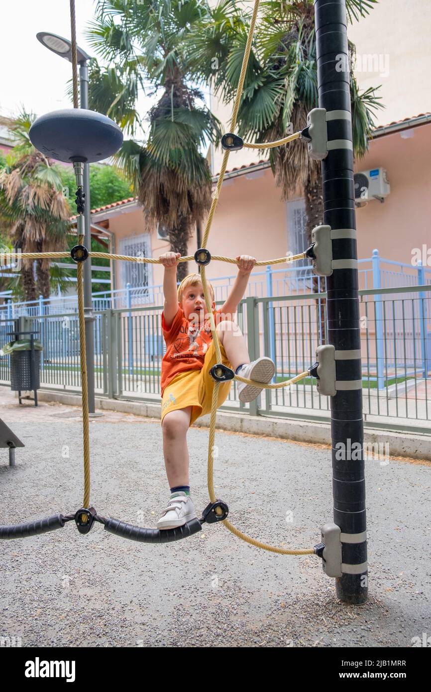 Cute little boy playing with a rope web in the playground Stock Photo ...