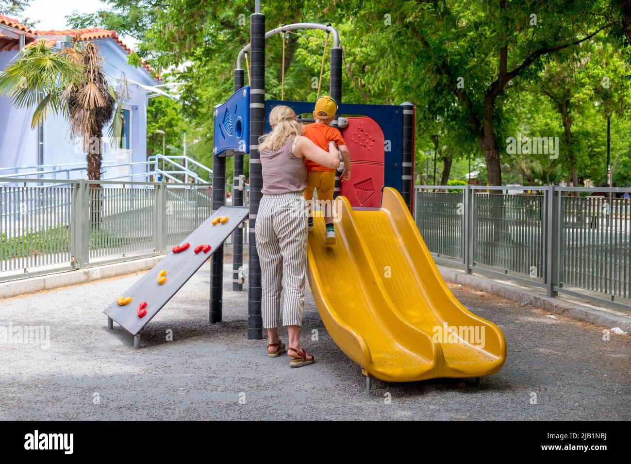 Mother looking after her kid in the playground Stock Photo - Alamy