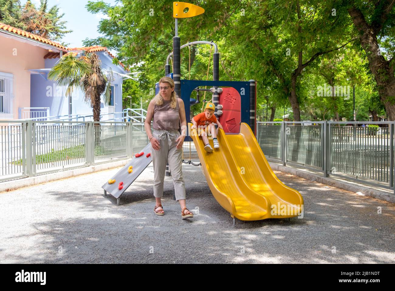 Mother looking after her kid in the playground Stock Photo - Alamy